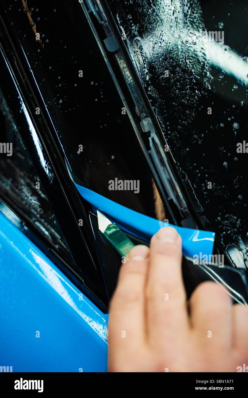 Cutting blue PPF with blade. Cutting blue paint protection film with ...