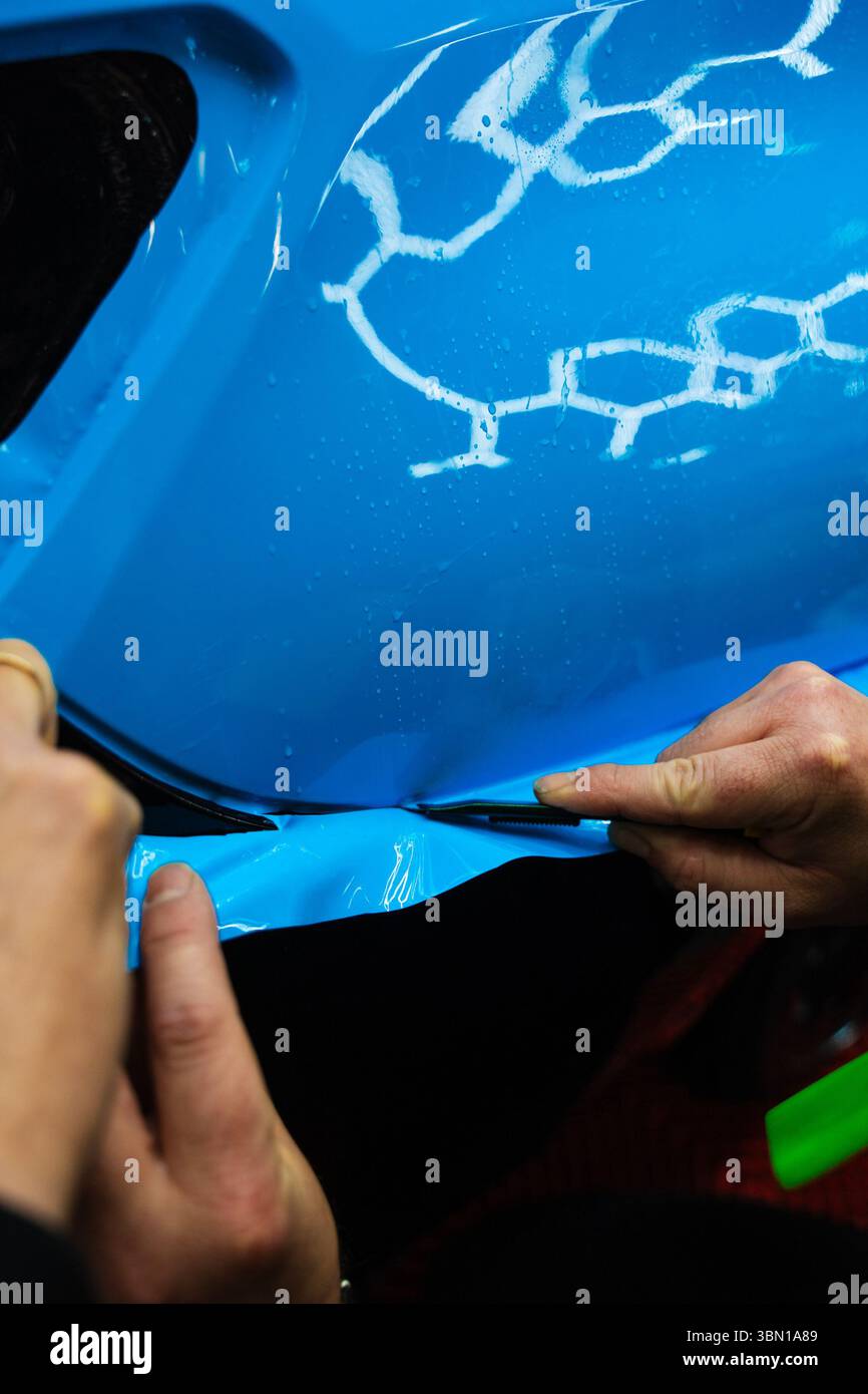 Cutting blue PPF with blade. Cutting blue paint protection film with ...