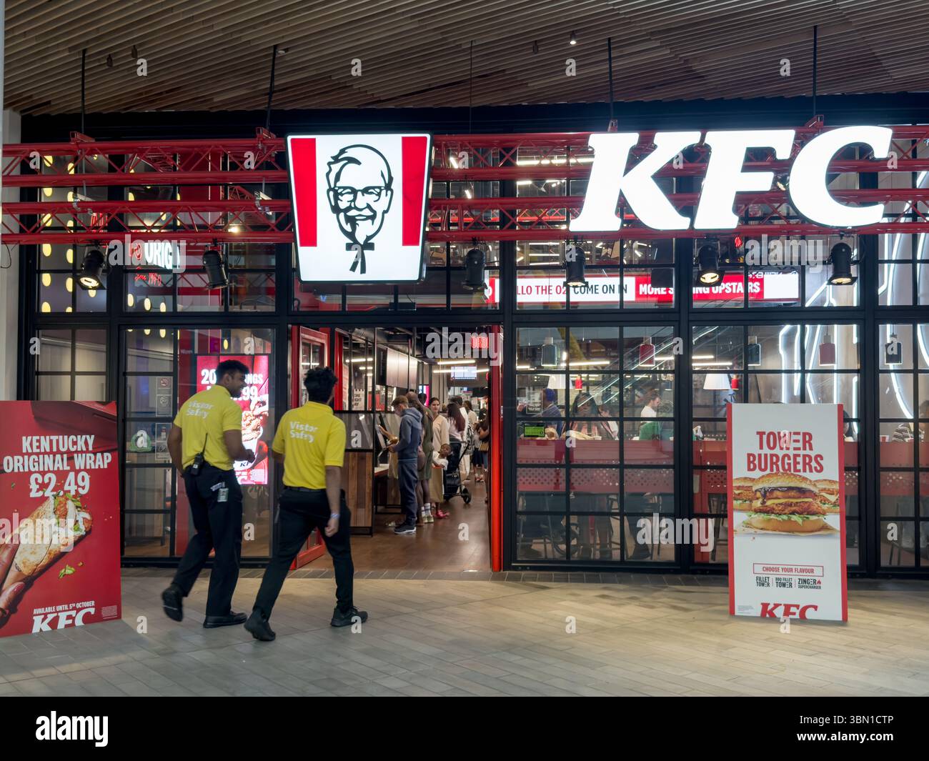 Two Customers in Yellow Polo Shirts Walk Toward KFC Entrance Featuring ...