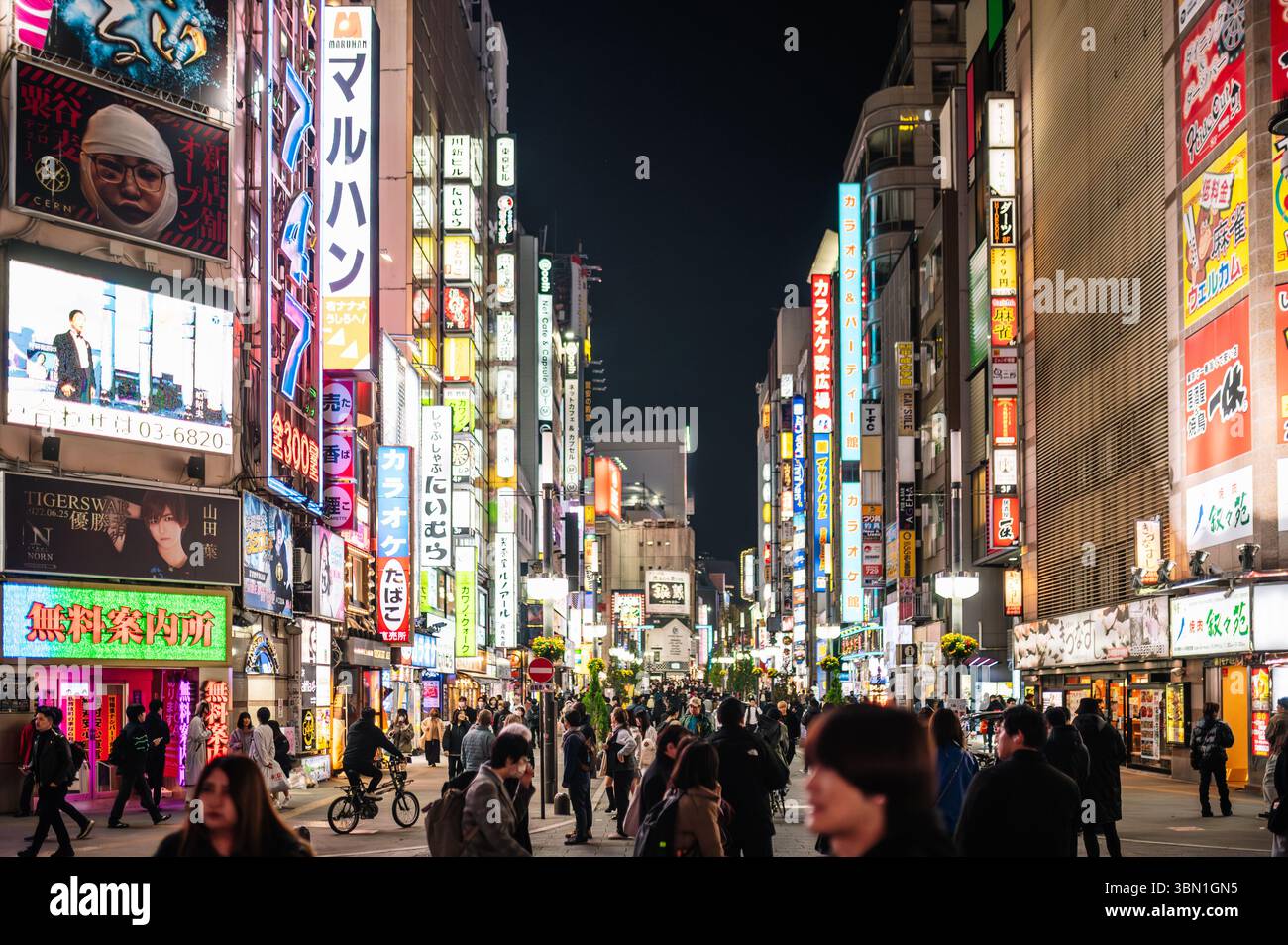 Crowded street in Kabukicho, Tokyo at night with colorful neon signs ...