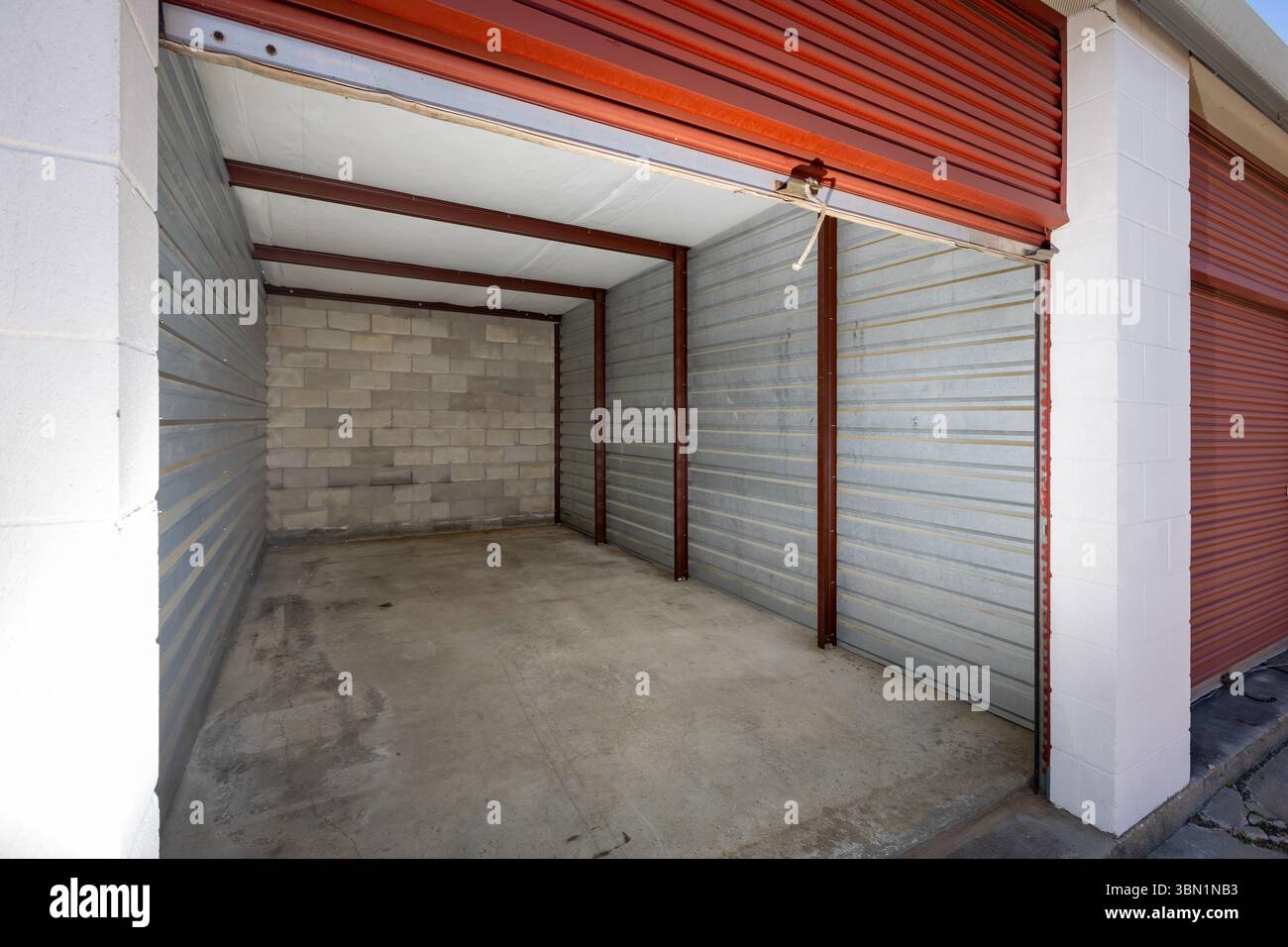 Empty self storage unit with roll up door Stock Photo - Alamy