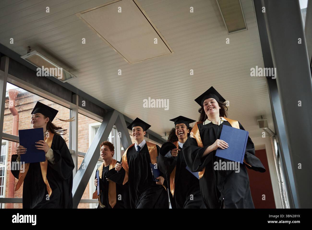 Group of multiethnic young university students wearing graduation caps ...