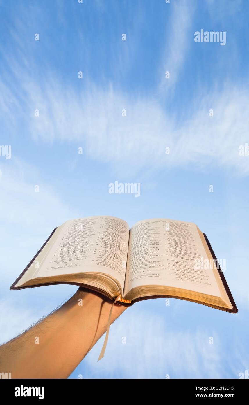 Low angle view of hand holding open Bible Stock Photo - Alamy