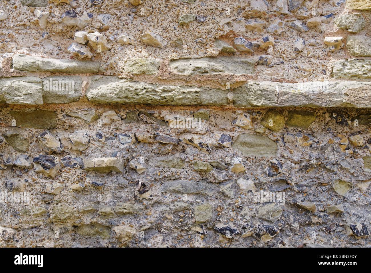 Masonry of the historic castle wall of Pevensey Castle, a Norman castle ...