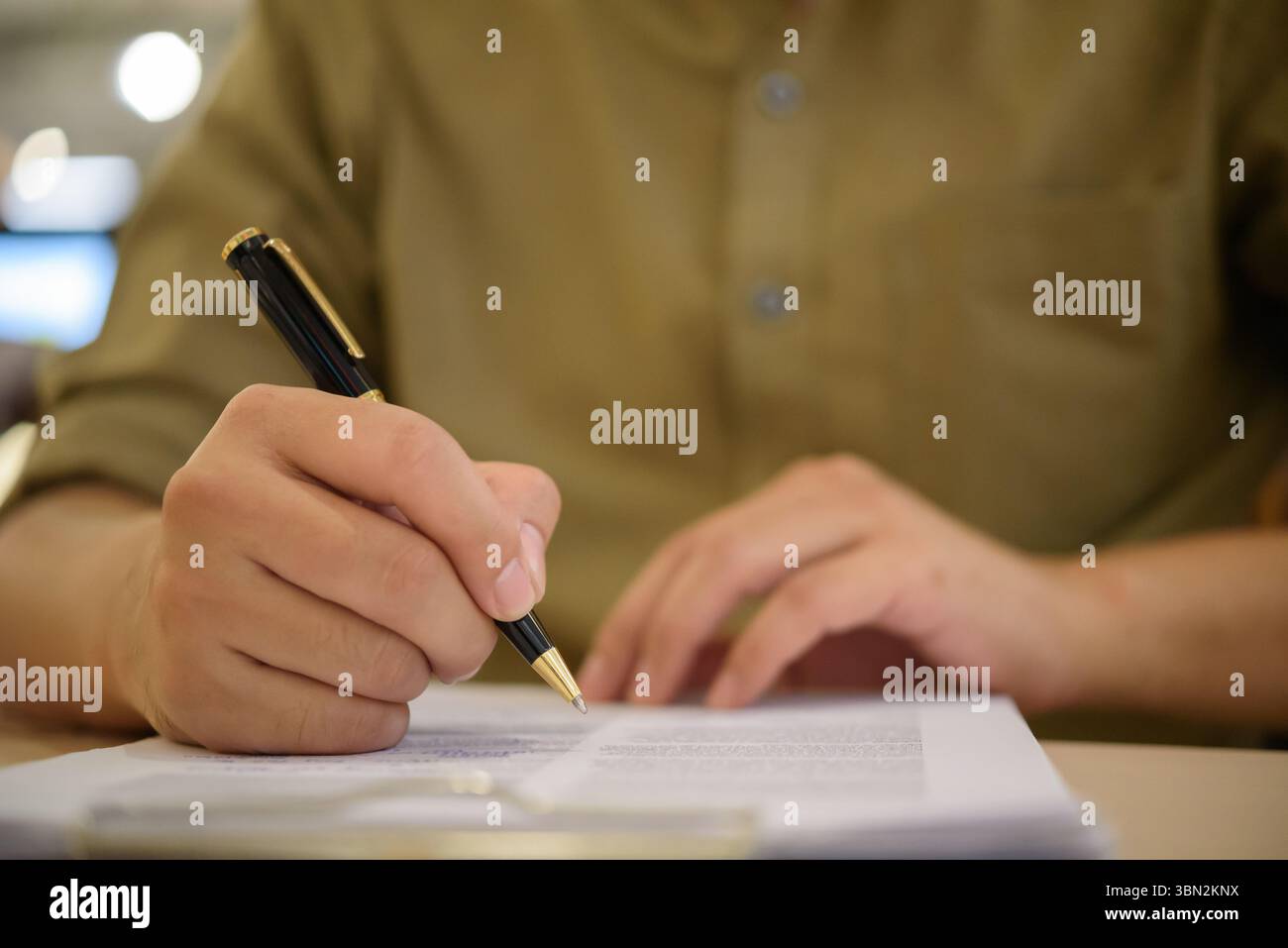 Signature being written on legal form, reflecting business approval, certified paperwork, and ...