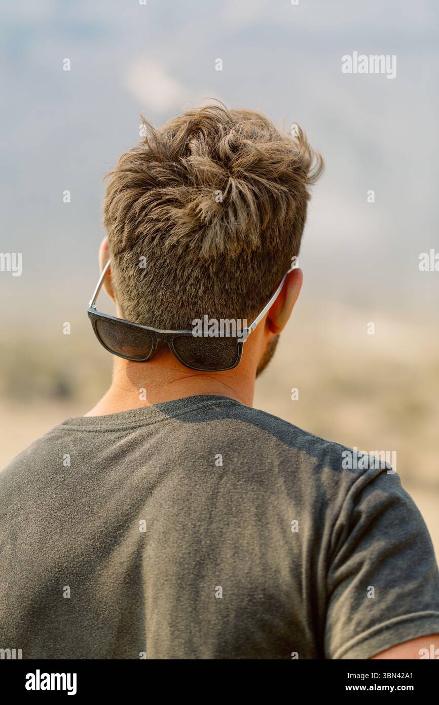 Festival goer wearing sunglasses around his neck looking at viewpoint ...