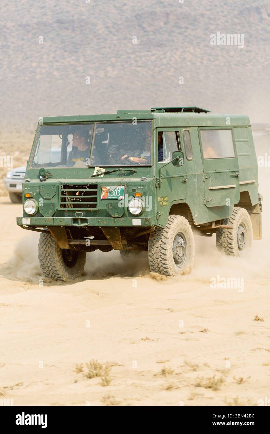Military vehicle moving fast on desert trail, raising dust Stock Photo ...