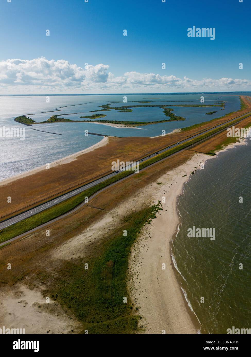 Aerial view of a narrow dam or causeway flanked by expansive water ...