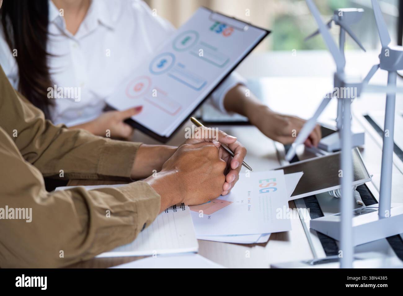 Sustainability Metrics Discussion. Team collaborating on ESG strategies ...