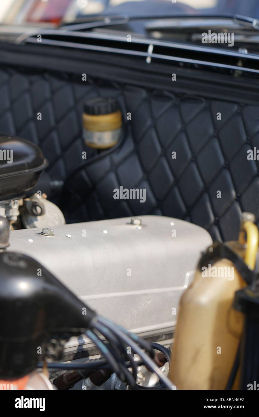 The engine and battery compartment of a classic car, with its detailed ...