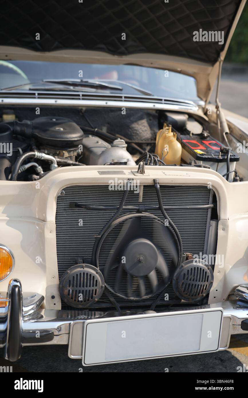 The engine and battery compartment of a classic car, with its detailed ...