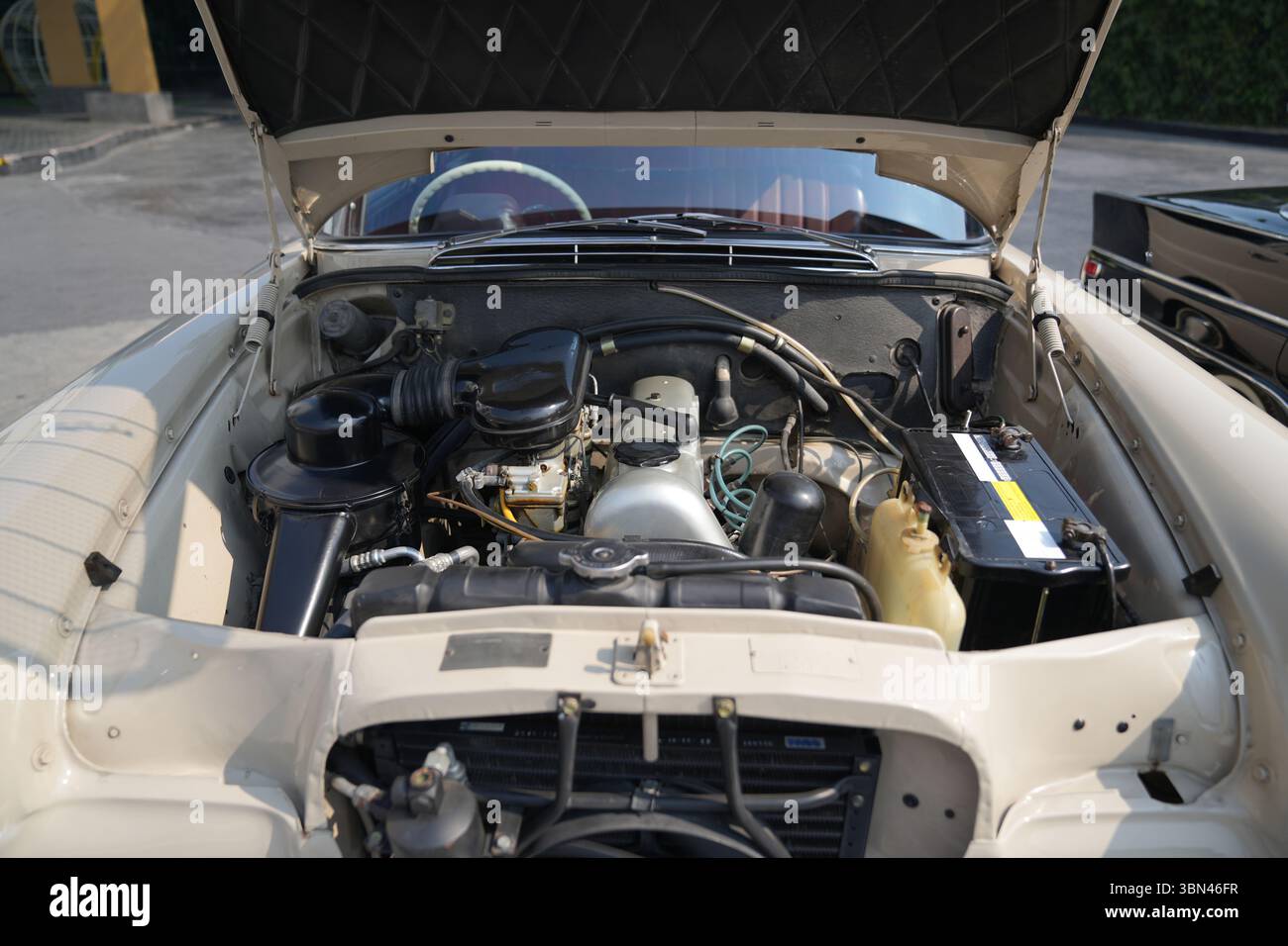 The engine and battery compartment of a classic car, with its detailed ...