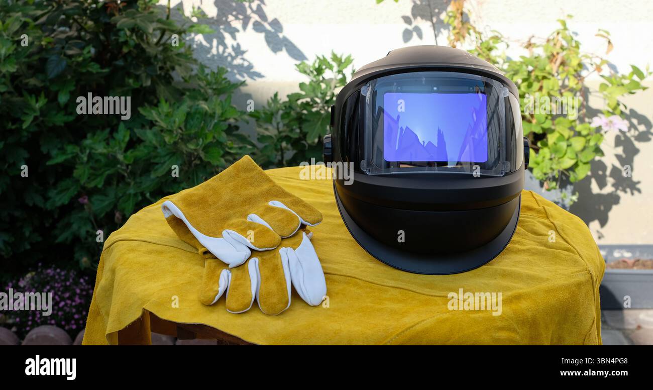Industrial still life with welding helmet and bright leather protective ...