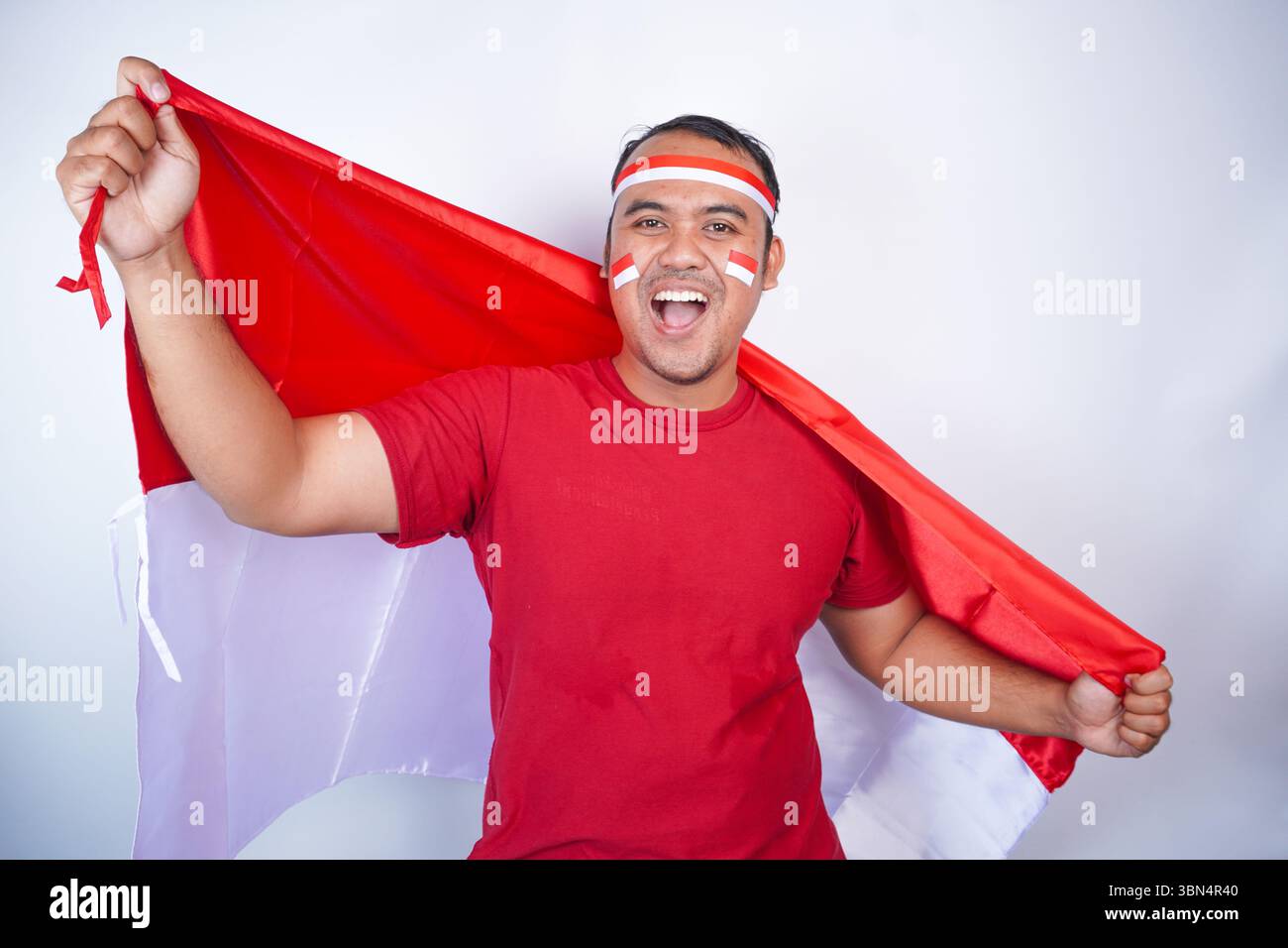 Asian young man using a flag clenched both first to celebrate Indonesia ...