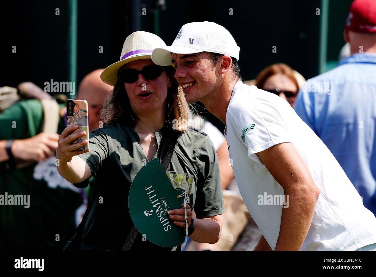 Oliver Tarvet takes photos with a spectator after winning his match ...