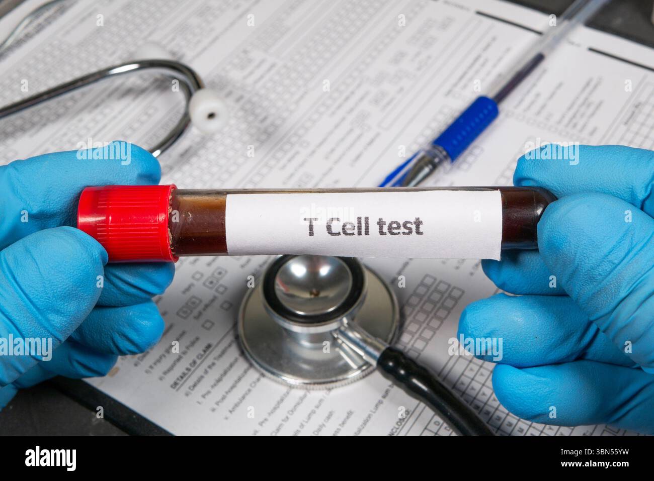 Gloved hands holding a t cell test tube over medical forms Stock Photo ...