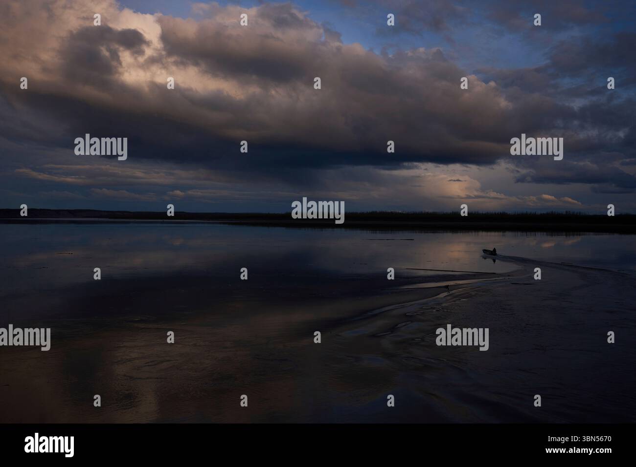 Jake Pogrebinsky drives his boat out to collect a floating log on the ...