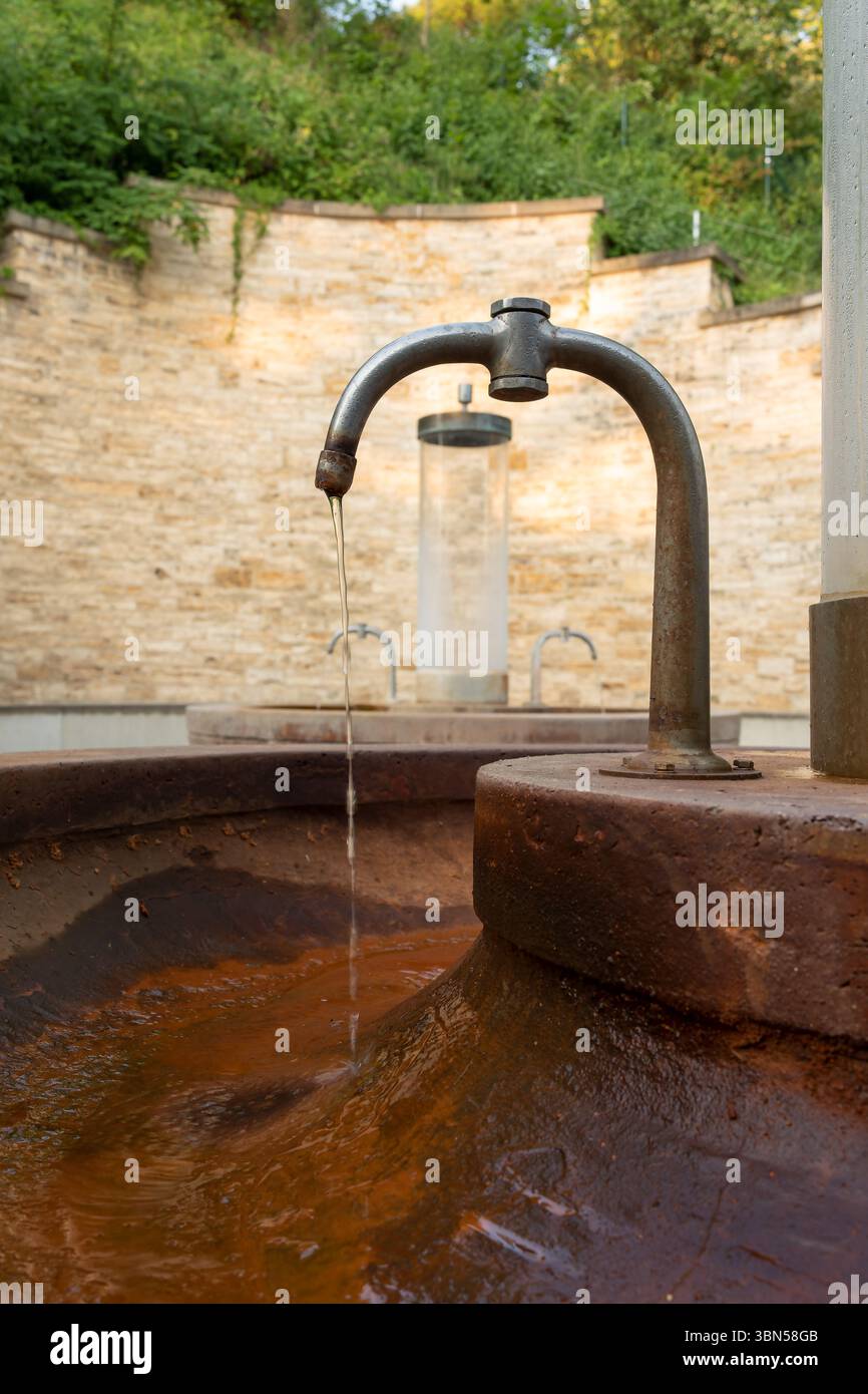 Mineral drinking water source. Drinking water pours from the tap on the ...