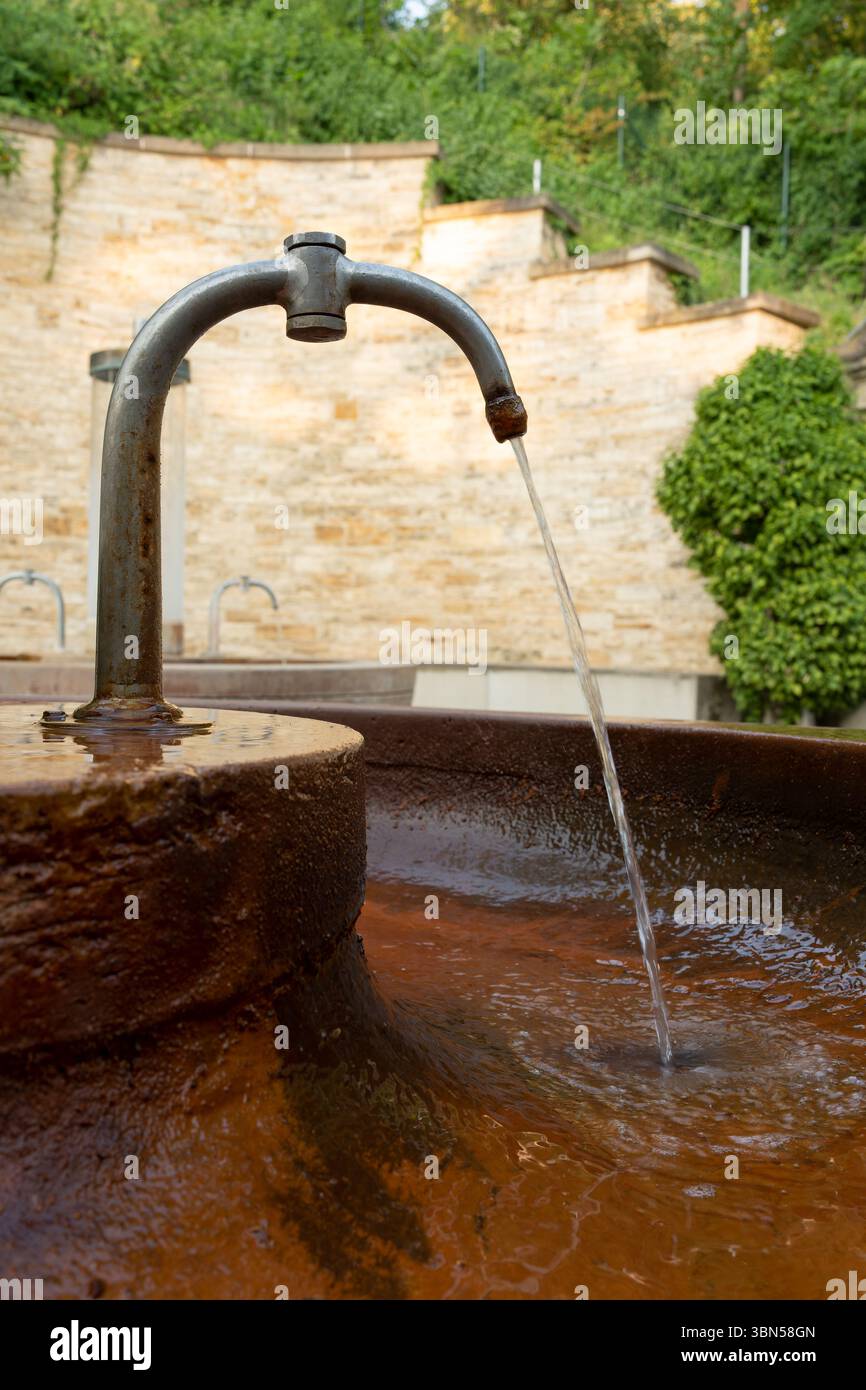 Mineral drinking water source. Drinking water pours from the tap on the ...