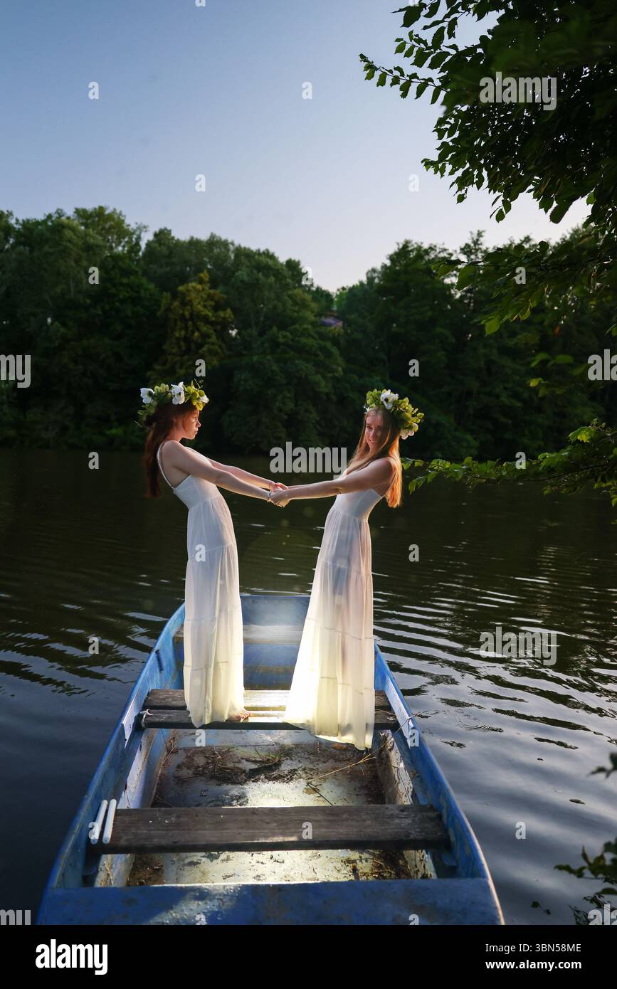 Symbolic summer solstice ceremony with girls in a boat holding glowing ...