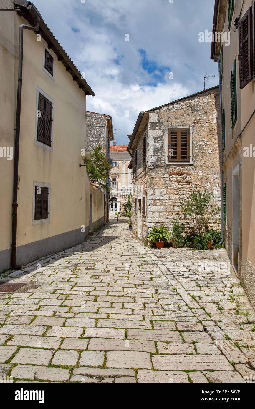 Charming cobblestone street in historic Mediterranean town with traditional stone houses, wooden ...