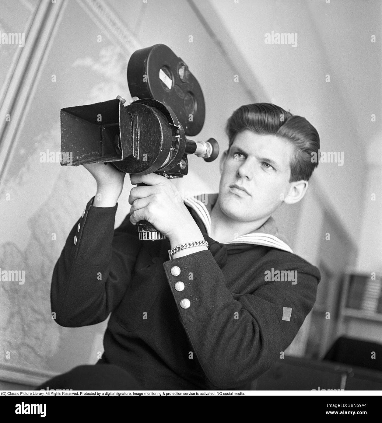 The Man with the Film Camera 1950. A man is holding a film camera and ...