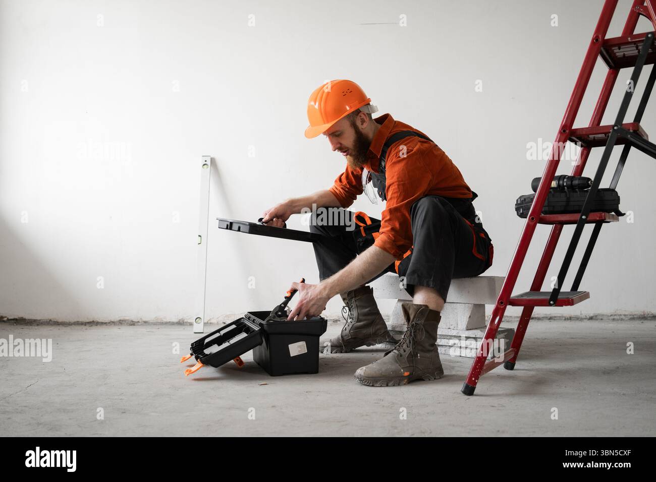 Male repairer. Handyman concept. Man in overalls opening toolbox ...