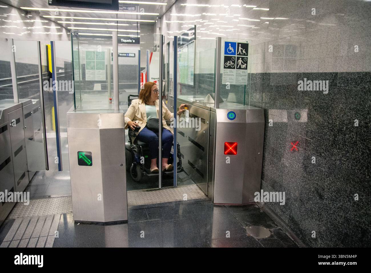 Woman in wheelchair passing through accessible subway turnstile ...