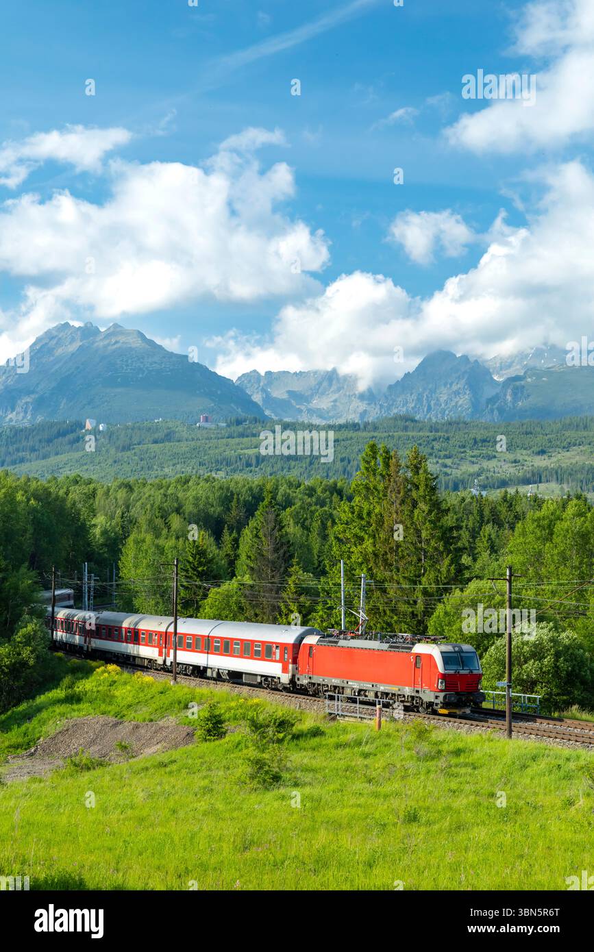 Red electric locomotive pulling passenger train in Strba, Slovakia ...