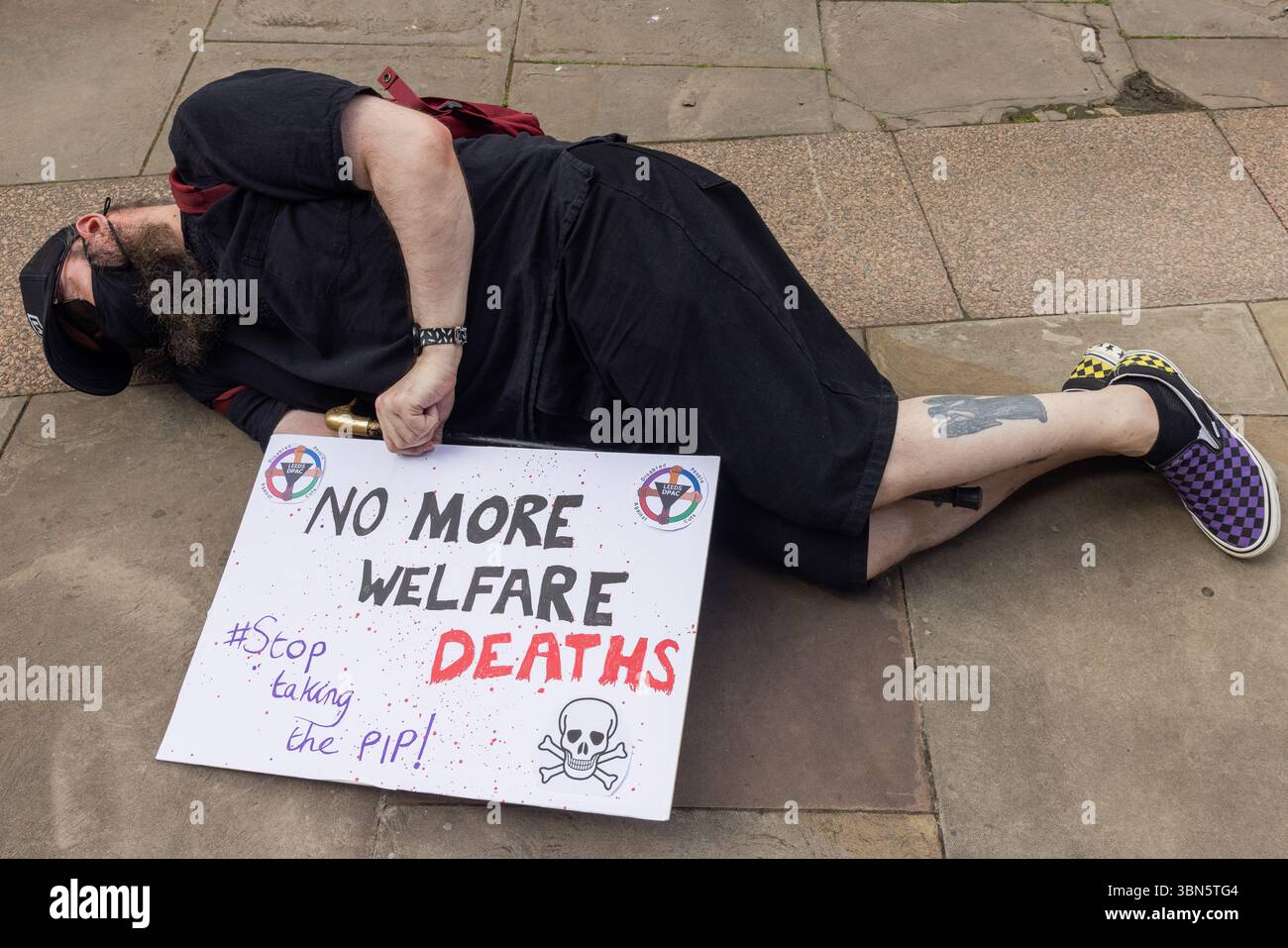 Leeds, UK. 30 JUN, 2025. Person poses dead alongside "No more Welfare ...