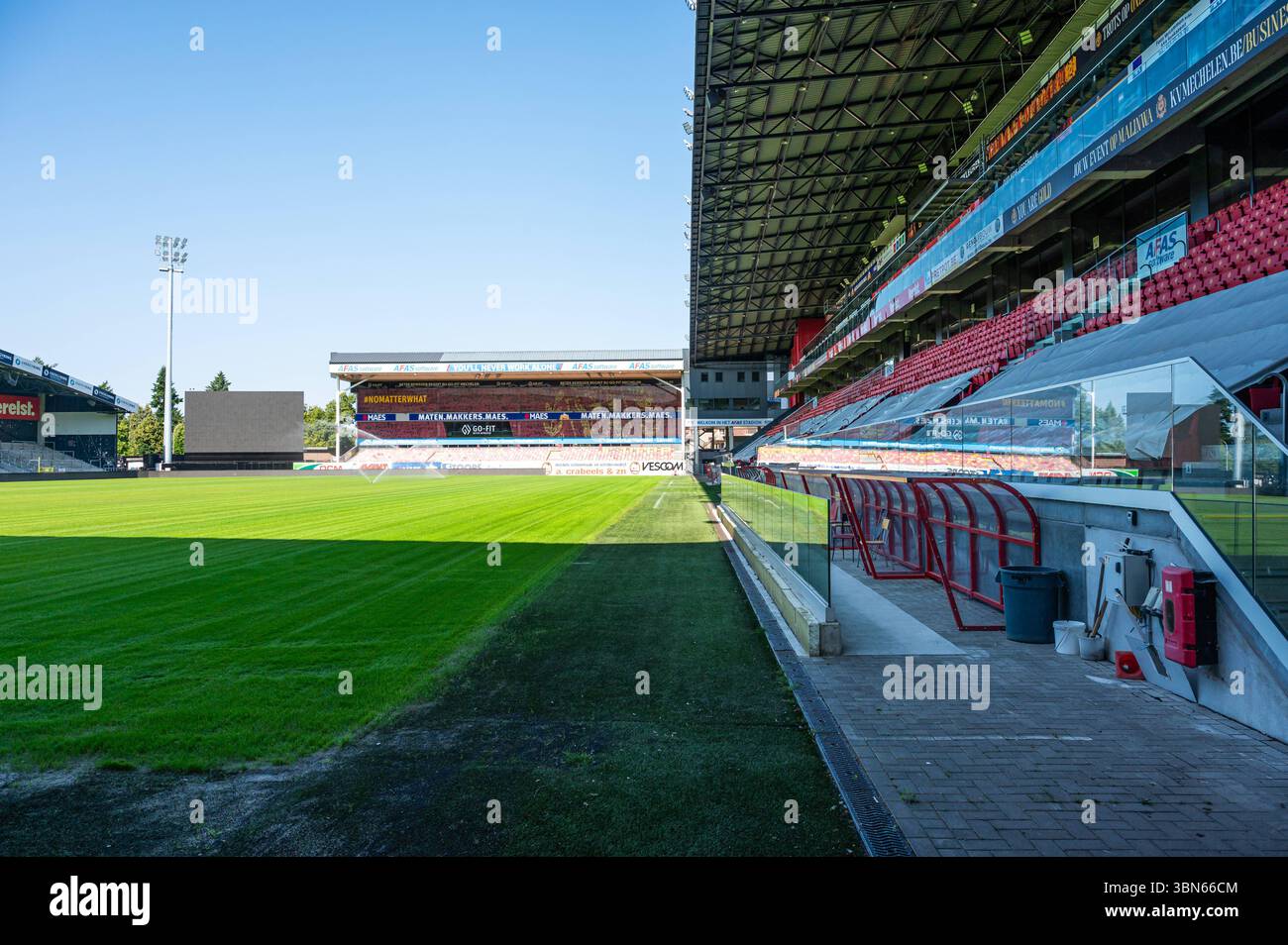 Green pitch, tribune and seats of the football stadium of KV Mechelen ...
