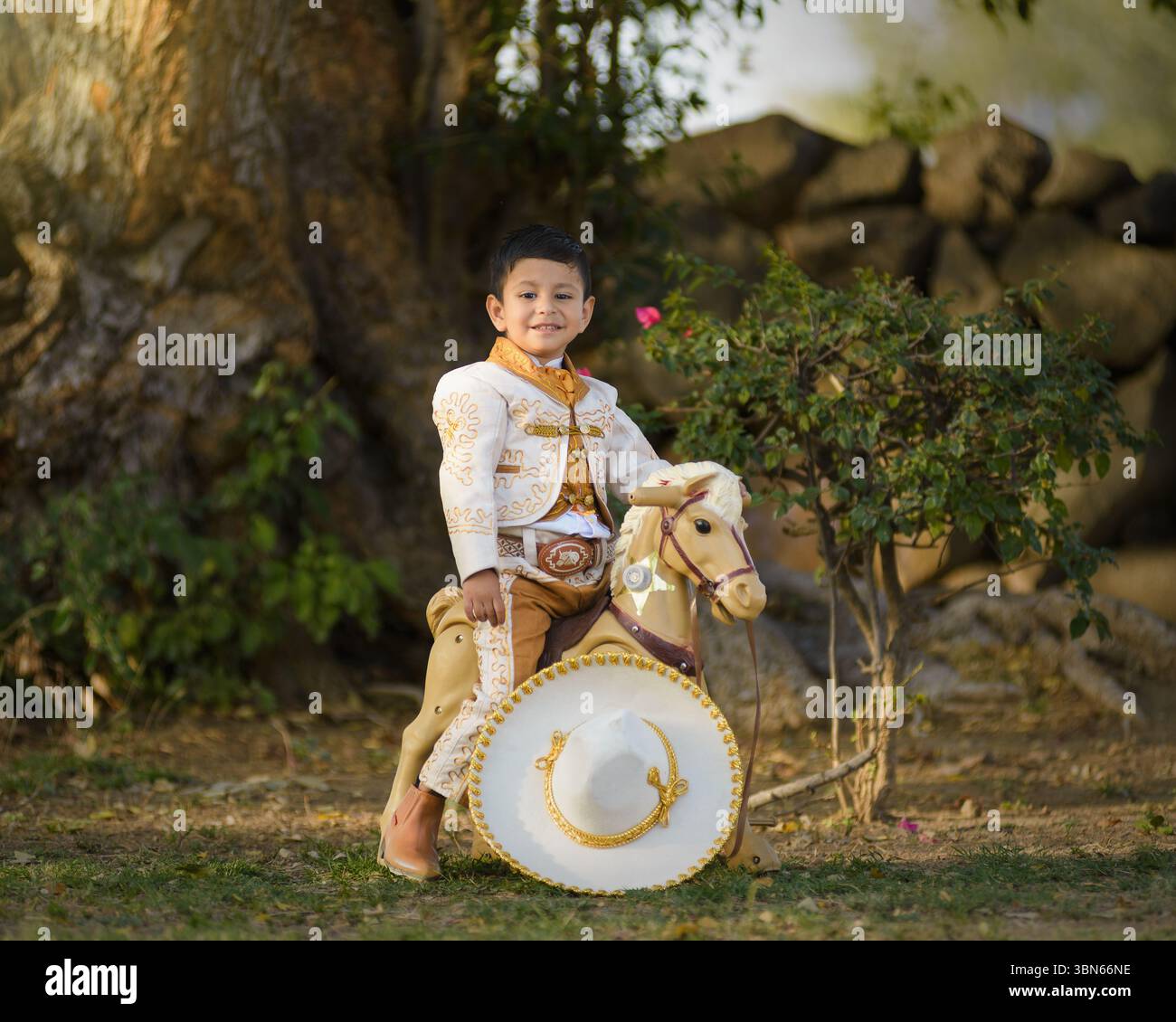 A child, dressed in a traditional charro costume, sits proudly atop a ...