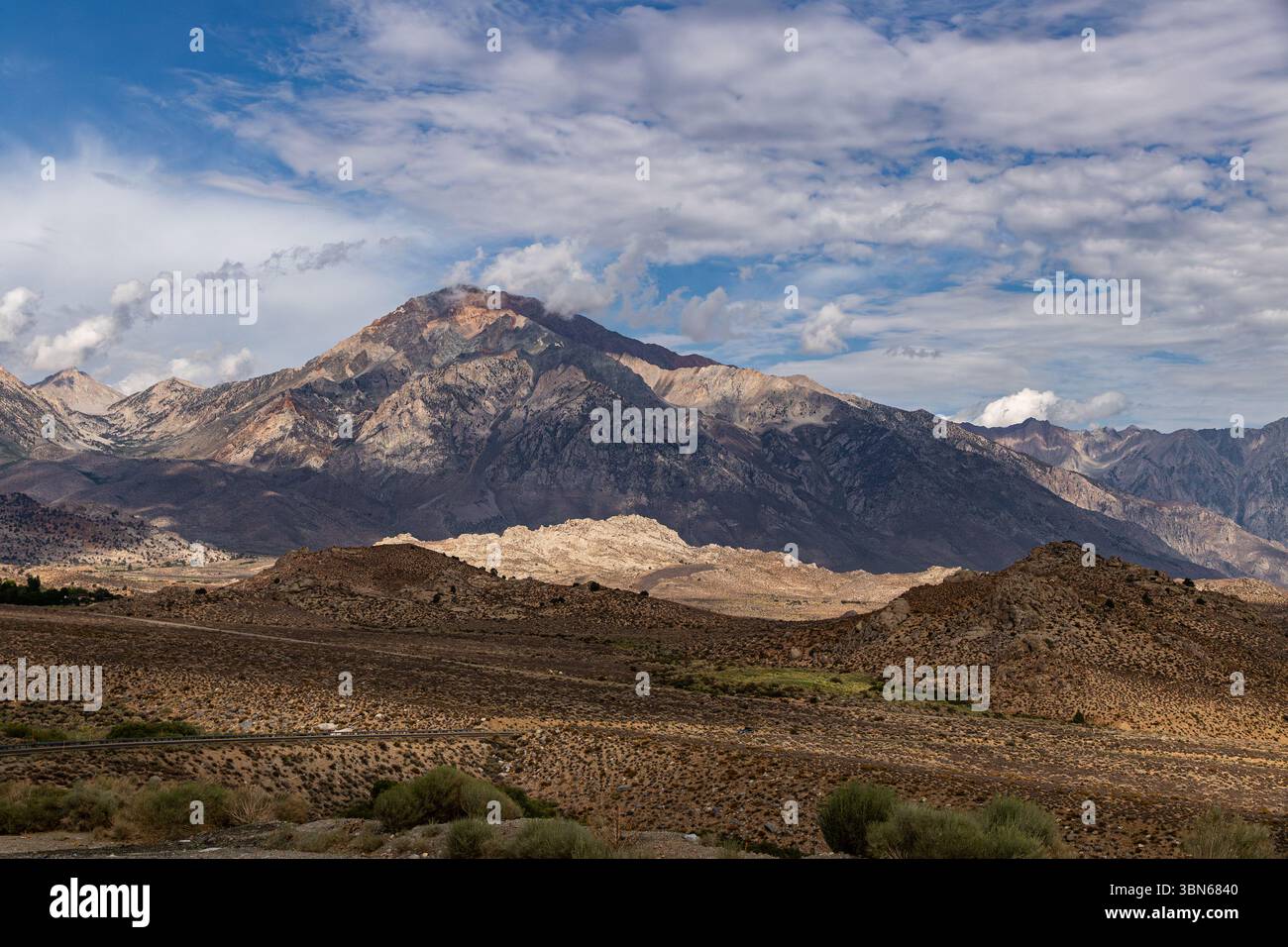 Mount Tom towering over the Buttermilk boulders with puffy clouds on a ...