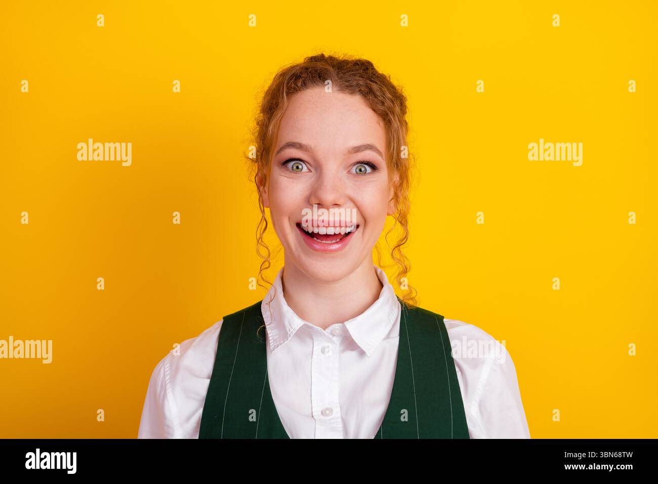 Excited young student expressing joy in front of bright yellow ...