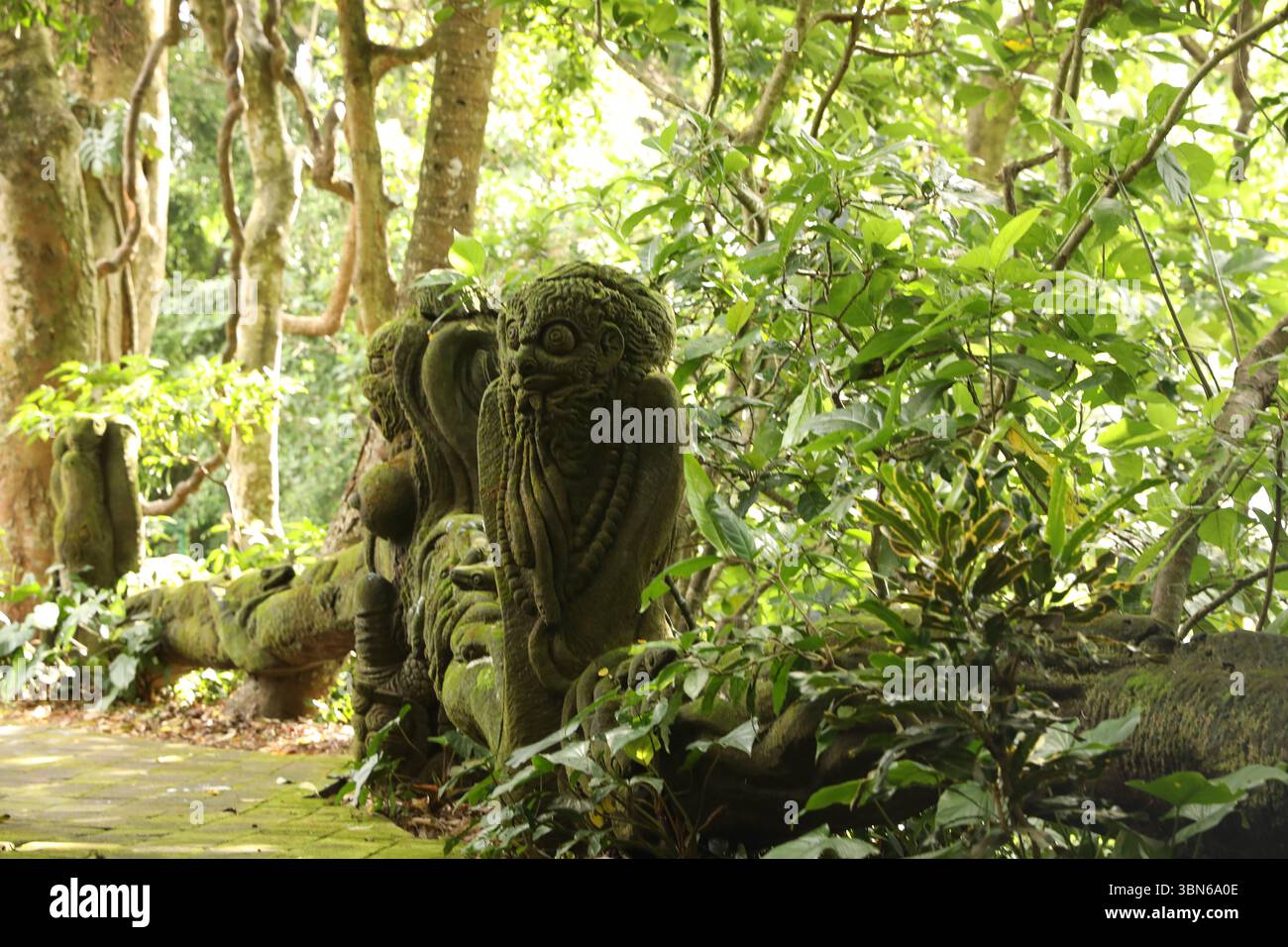 Bali, Indonesia - June 2, 2025: Ancient sculptures and lush greenery in ...
