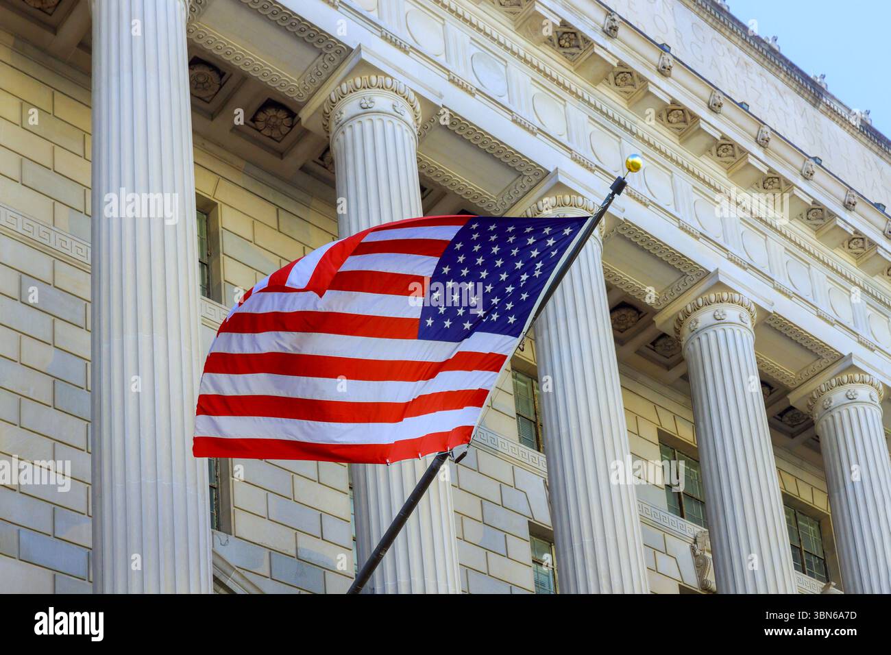 An American flag waves in front of grand government structure featuring ...