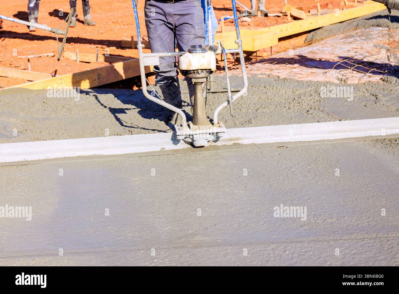 Workers are using concrete leveling tool to smooth out freshly poured ...