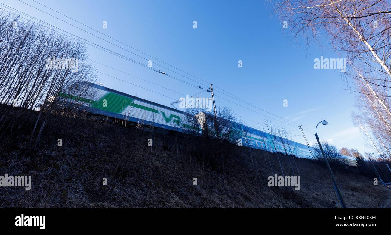 Long range electric passenger train driving on top of embankment ...