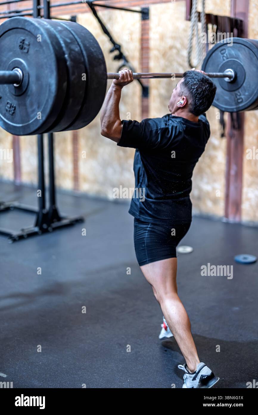 A weightlifting athlete demonstrates strength and focus while executing ...
