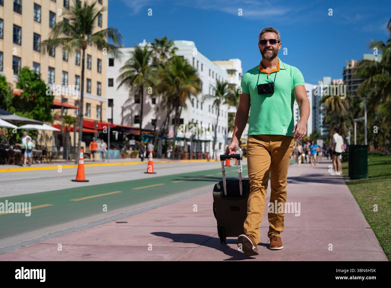 A tourist walks through the sunny streets of Miami. A man tourist ...