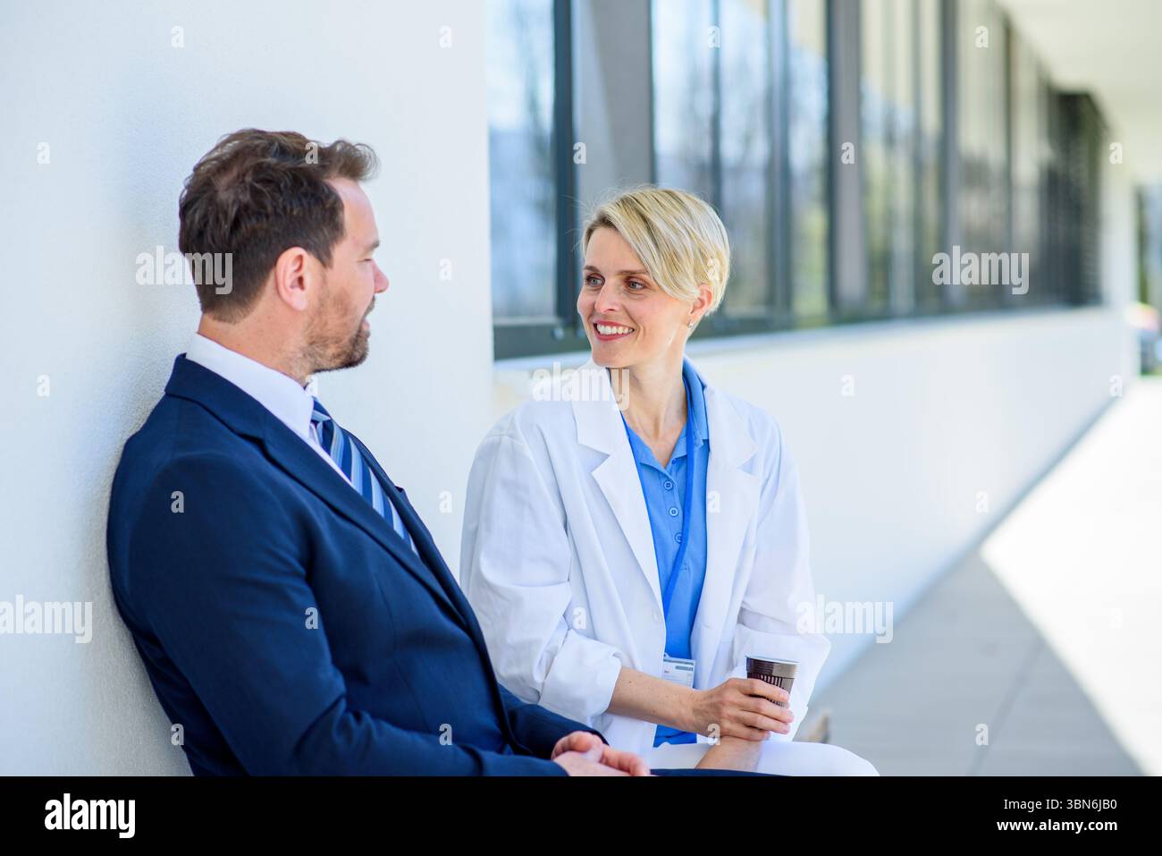 Doctor and pharmaceutical representative talking about new drug, in ...