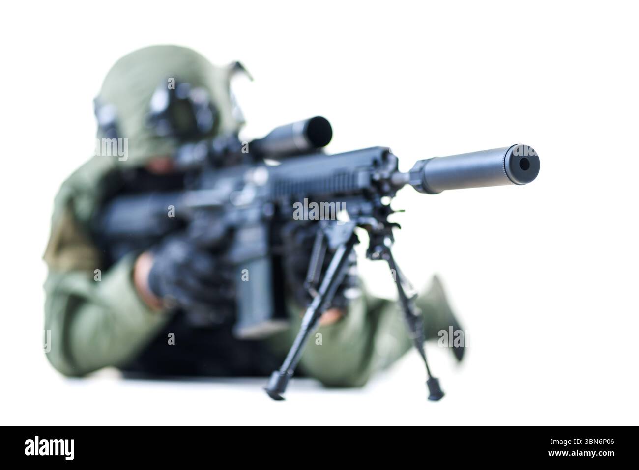 Focused capture of a soldier in combat attire aiming a rifle equipped ...