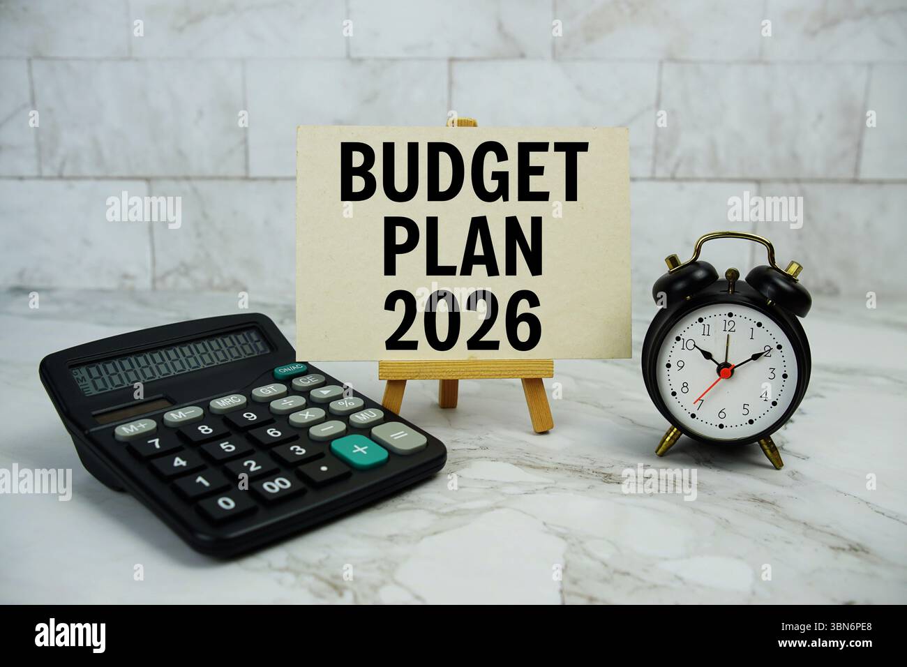 Budget plan 2026 text written on paper card with calculator and alarm ...