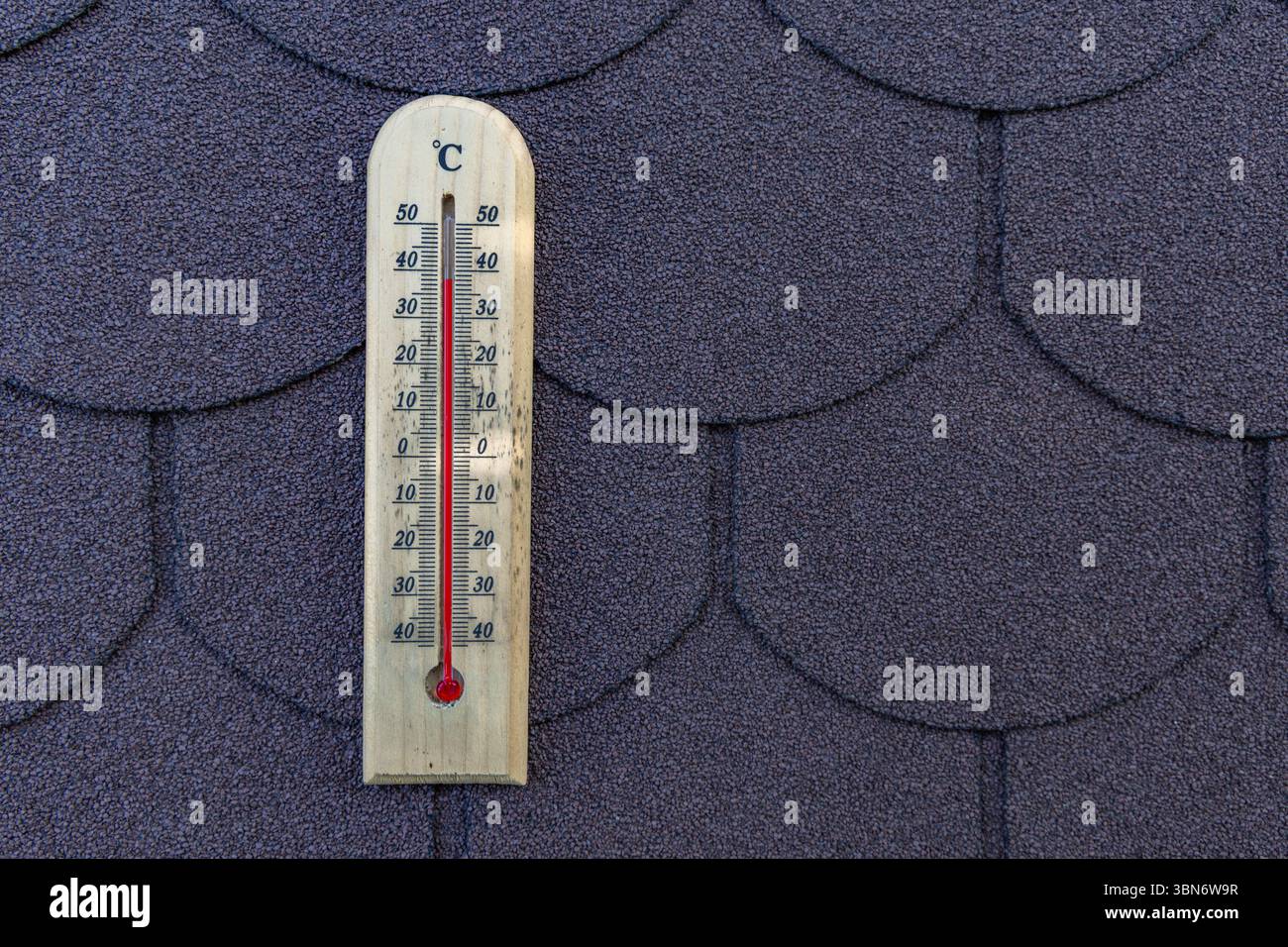 Measuring the temperature on the roof of the house, a wooden ...