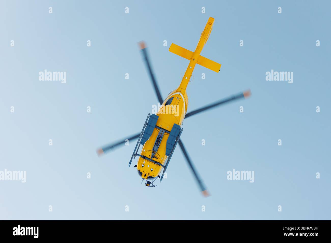 Scenic bottom view modern yellow rescue emergency mountain helicopter ...