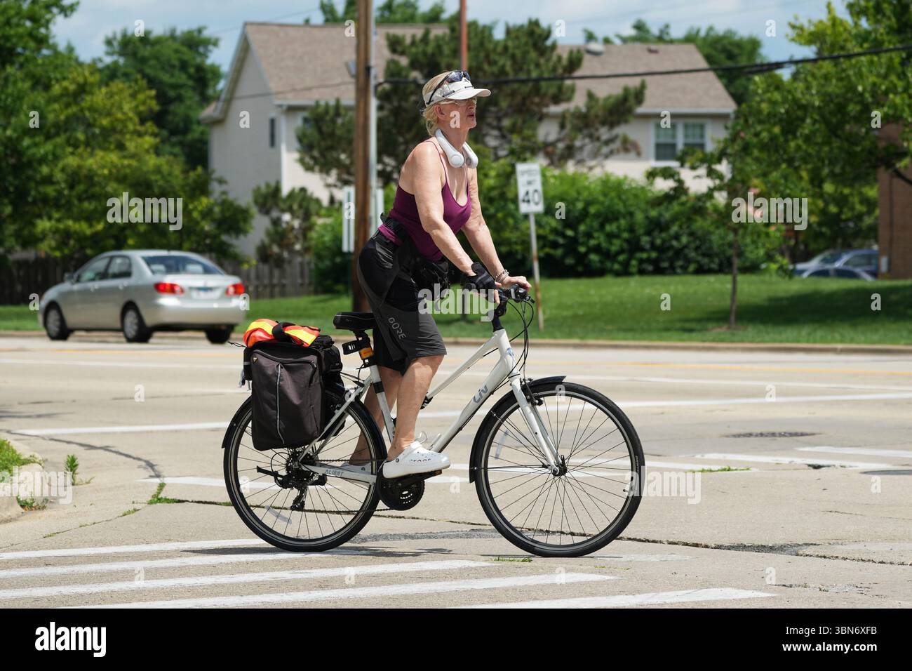 A woman rides her bicycle during hot weather Monday, June 30, 2025, in Mount Prospect, Ill. (AP ...