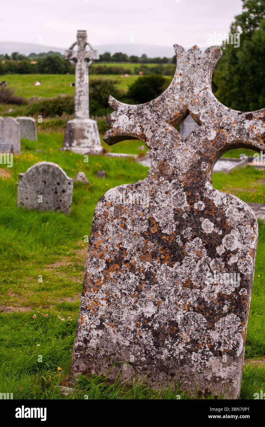 A cemetery with a cross headstone in the middle. The headstone is ...
