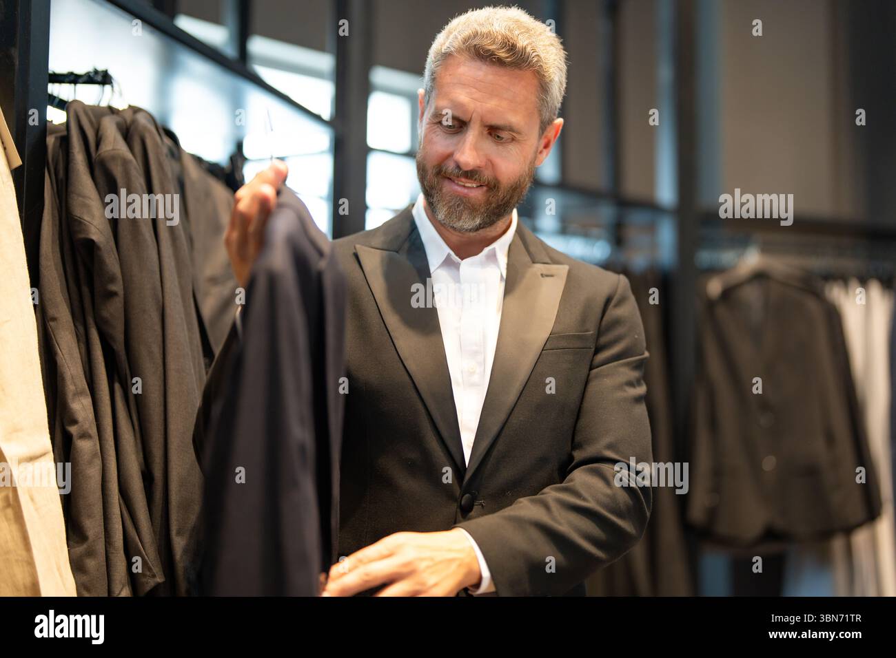 A boutique consultant helps a customer find the perfect suit. A luxury ...