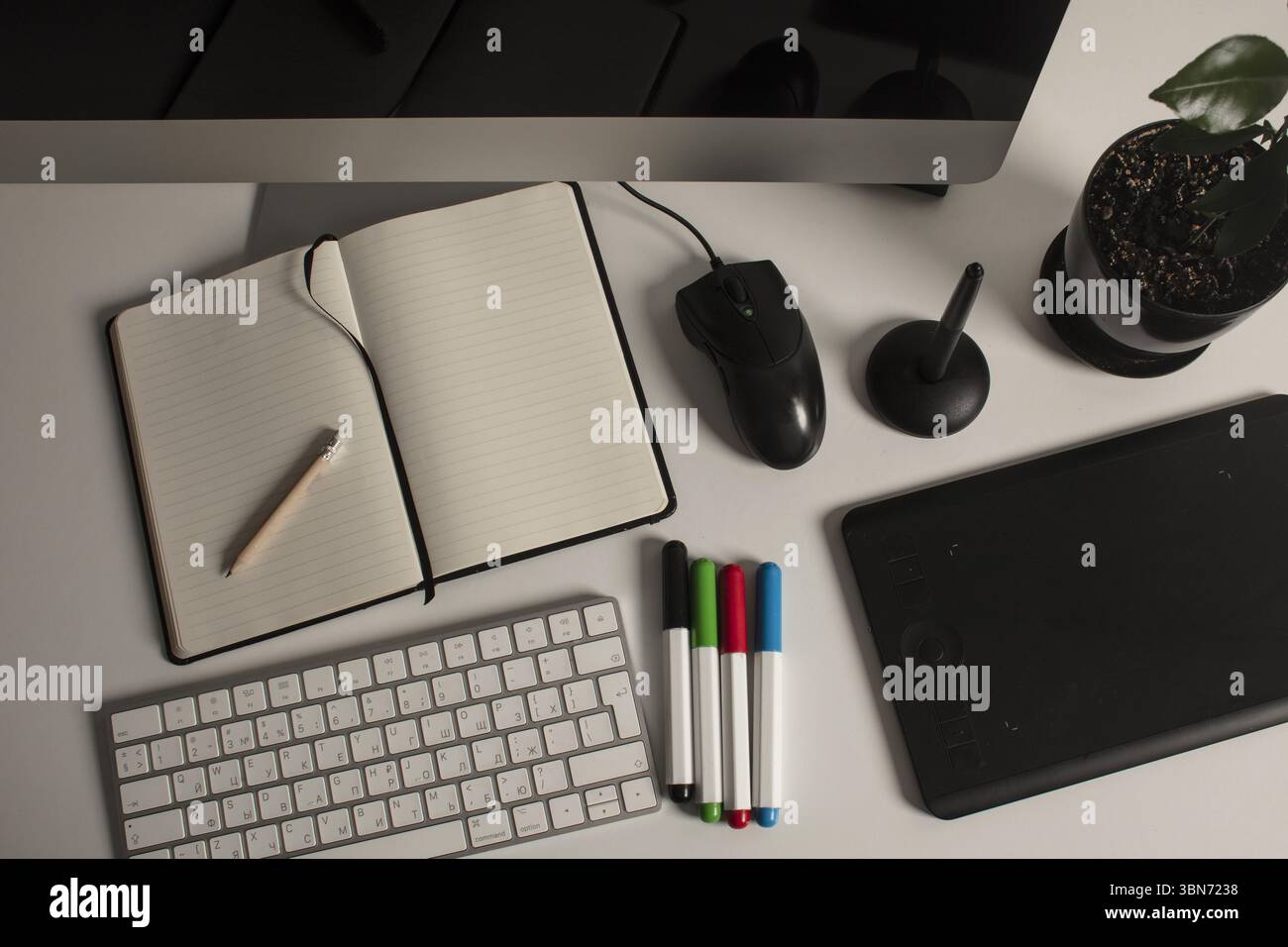 Modern workspace with keyboard, black notebook, pencil, graphic tablet ...