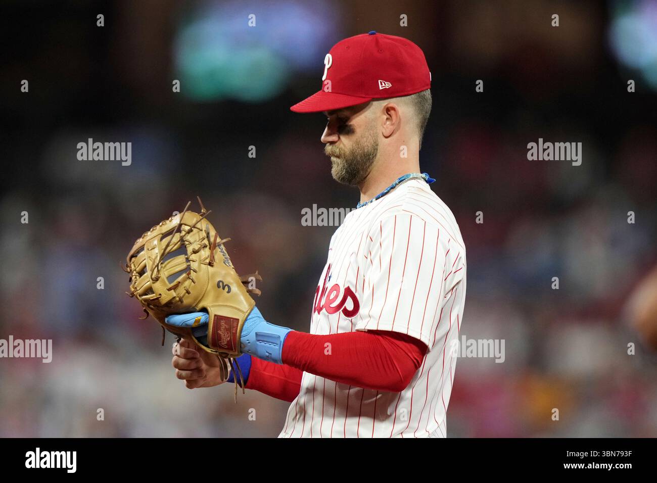 Philadelphia Phillies first baseman Bryce Harper looks at his glove ...